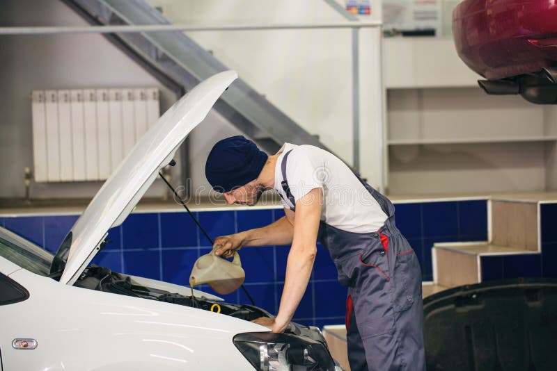 Auto Mechanic is Changing Motor Oil into a Engine Stock Photo - Image ...
