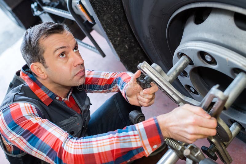 Auto Mechanic Checking Tyre in Garage Stock Photo - Image of fixing ...