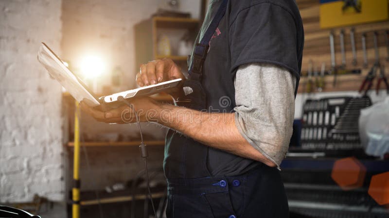 Auto Mechanic Diagnoses a Car Using a Computer. Car Workshop. Close-up ...