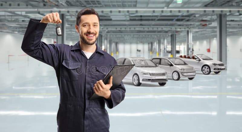 Auto Mechanic Holding Car Key and a Clipboard in a Car Garage Stock ...