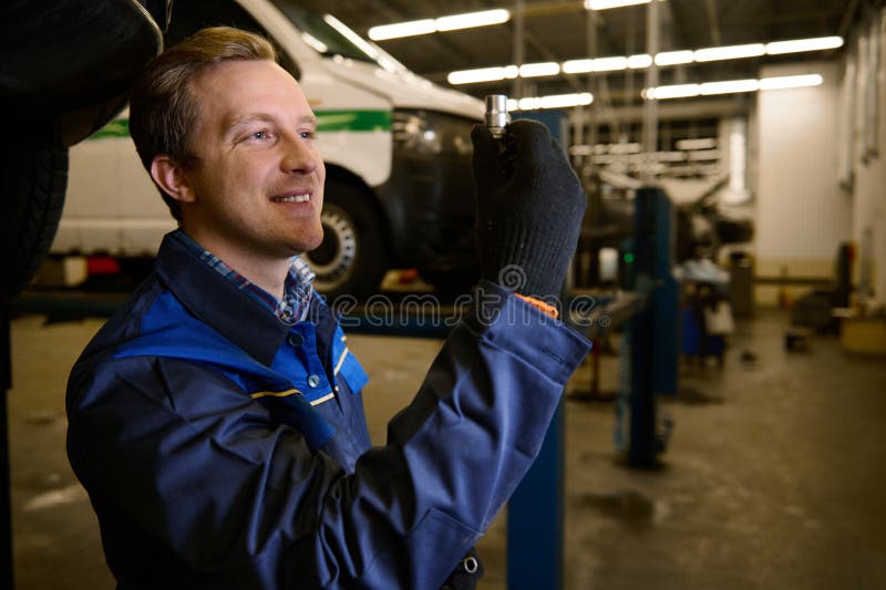 Auto Mechanic Picks Up a Nut while Servicing a Car in a Car Workshop ...
