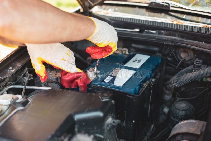 An Auto Mechanic is Repairing a Car. Removing the Battery Stock Photo ...