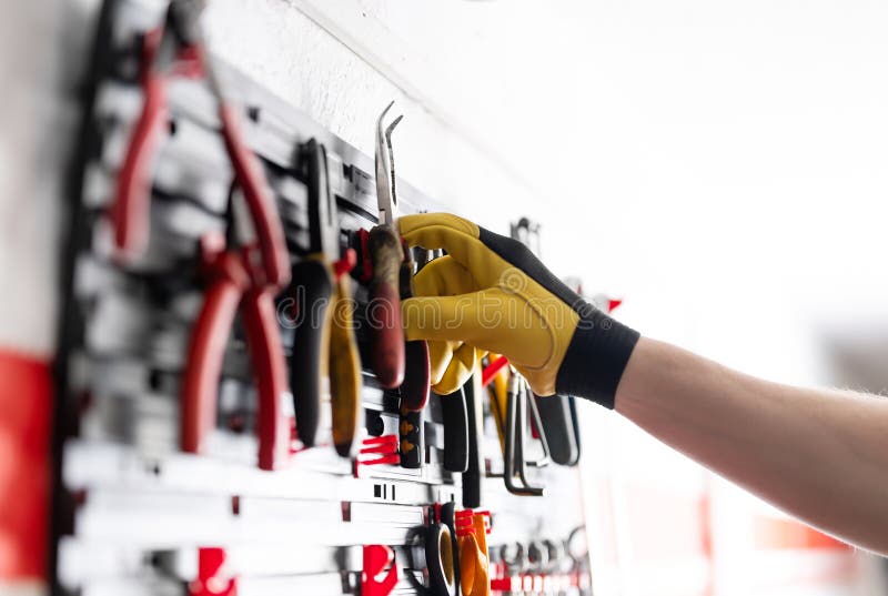 Auto Mechanic Taking Pliers from Wall Tool Panel Stock Image - Image of ...