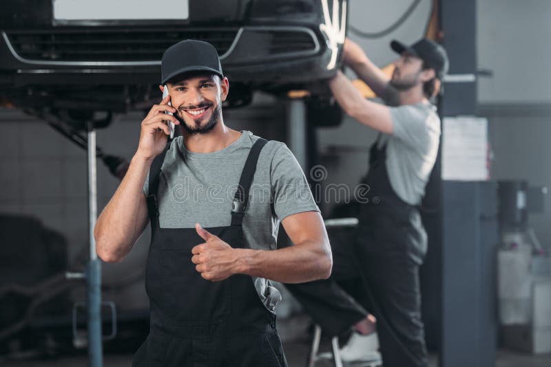 Auto Mechanic Talking on Smartphone and Showing Thumb Up while ...