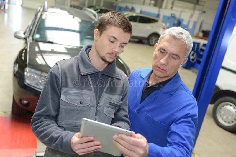 Auto Mechanic Teacher and Trainee Performing Tests at Mechanic School ...