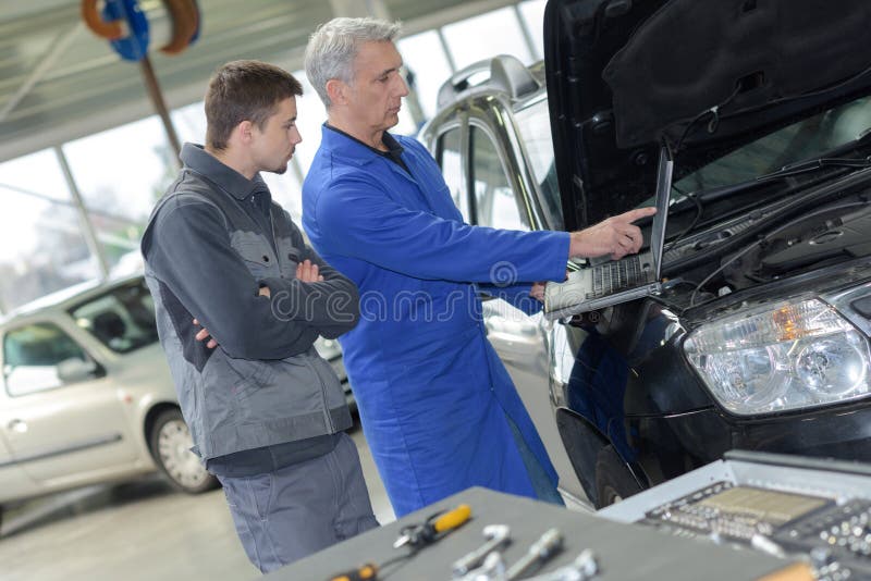Auto Mechanic Teacher and Trainee Performing Tests at Mechanic School ...