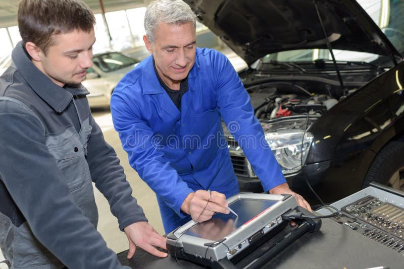 Auto Mechanic Teacher and Trainee Performing Tests at Mechanic School ...