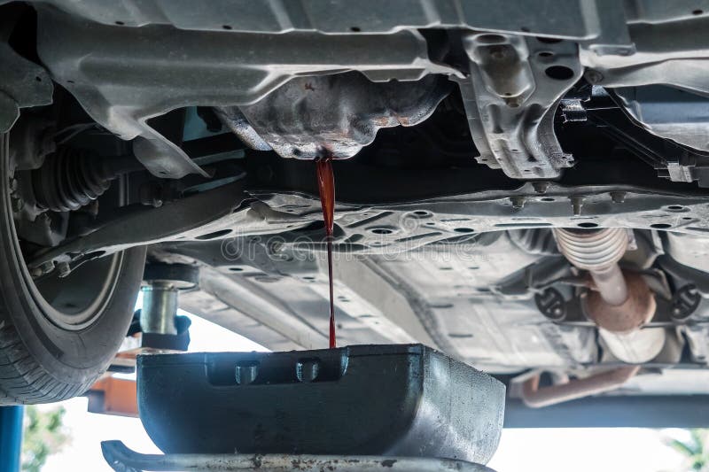 Auto Mechanic Unscrews Engine Oil Drain Plug so that the Old Used Oil ...