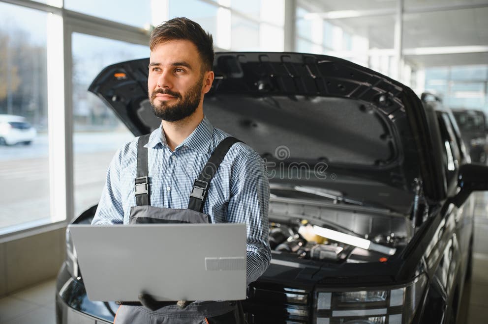 Auto Mechanic Using Computer Diagnostic Program while Repairing Car in ...