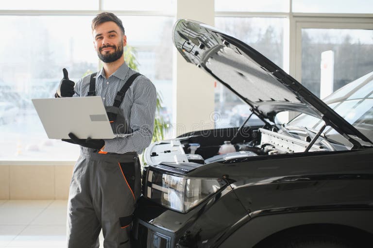 Auto Mechanic Using Computer Diagnostic Program while Repairing Car in ...