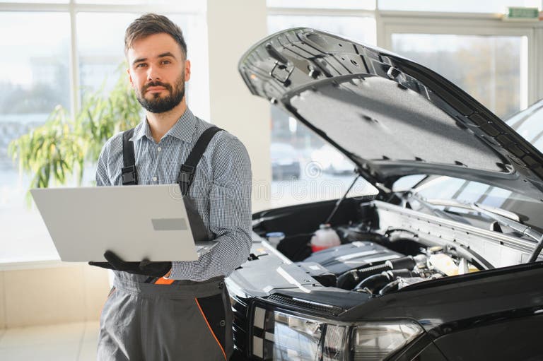 Auto Mechanic Using Computer Diagnostic Program while Repairing Car in ...