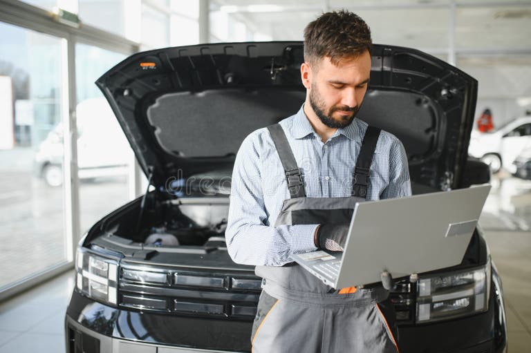 Auto Mechanic Using Computer Diagnostic Program while Repairing Car in ...