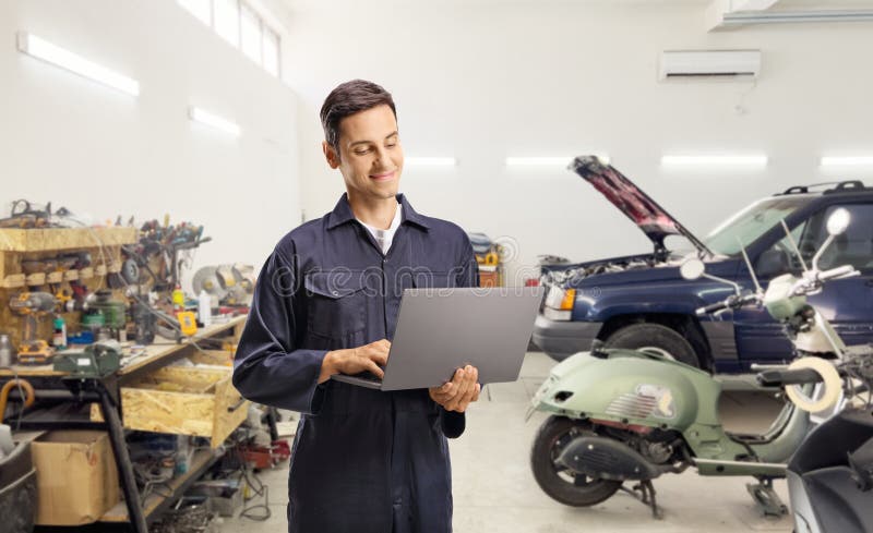 Auto Mechanic Using a Laptop Computer in a Car Garage Stock Photo ...