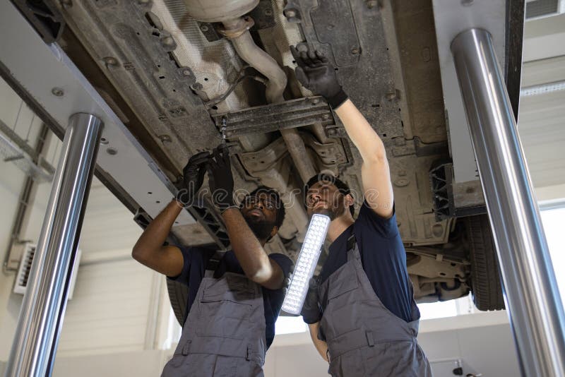 Auto Mechanics Inspecting Car Underside in Garage Workshop Stock Photo ...