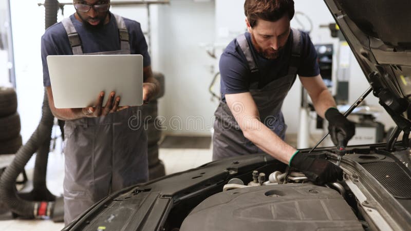 Auto Mechanics Working Together in Garage with Laptop Stock Video ...