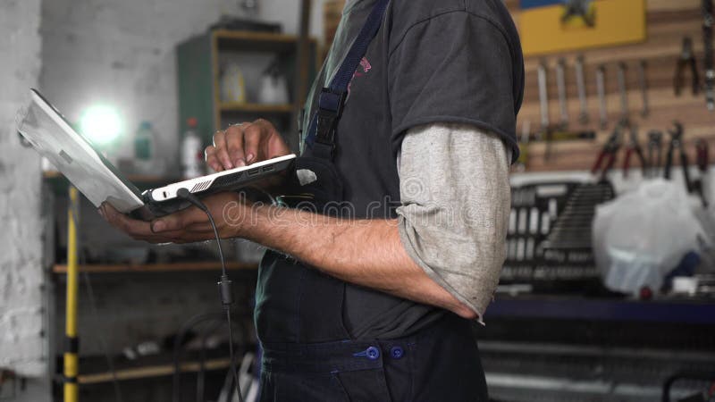 Auto Repairman Diagnoses a Car Using a Computer. Car Workshop. Close-up ...
