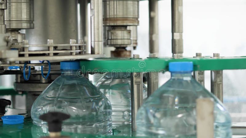 Automatic Capping of Plastic Bottles. Drinking Water Production Line at ...