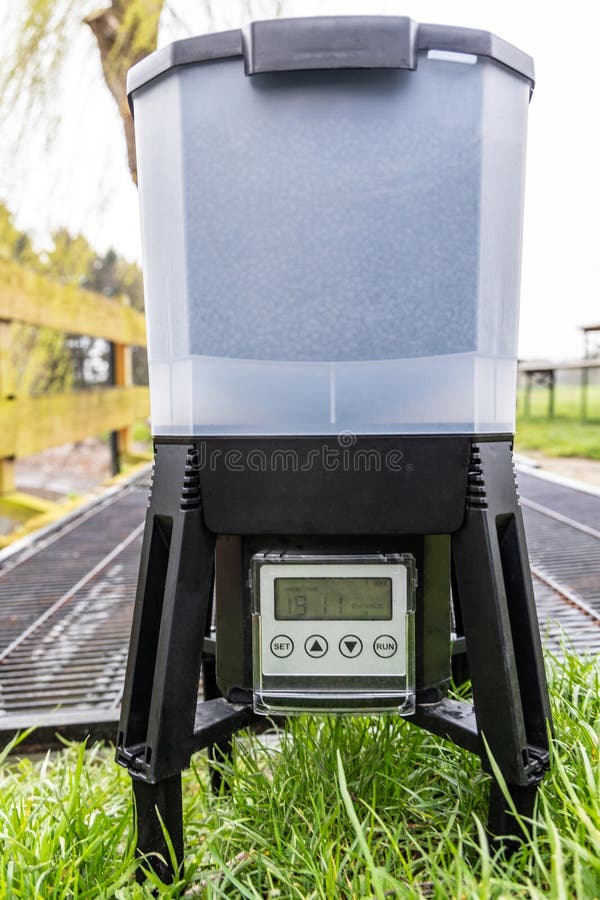An Automatic Fish Feeder Stands at the Edge of a Trout Pool Stock Photo ...