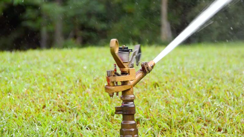 Automatic Sprinkler Spraying Water on a Grass Field Stock Footage ...