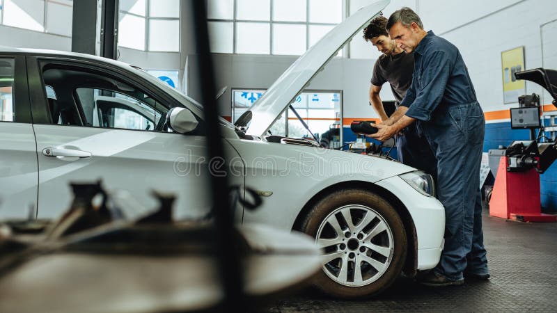 Mechanics Inspecting a Car Using an Electronic Device Stock Image ...
