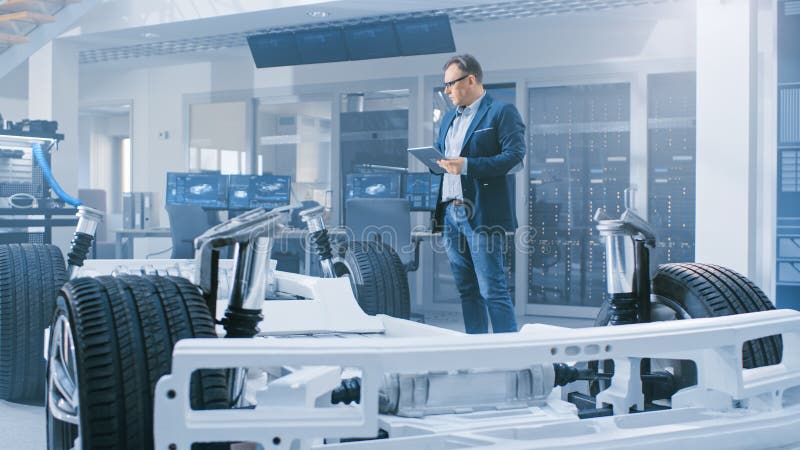 Automotive Design Engineer Looking at Technical Drawing of an Electric ...