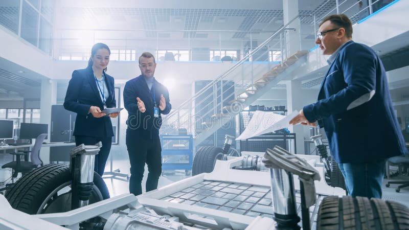 Automotive Design Engineers Talking while Working on Electric Car ...