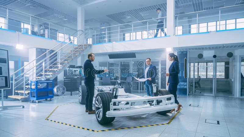 Automotive Design Engineers Talking while Working on Electric Car ...