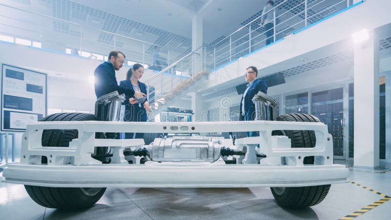 Automotive Design Engineers Talking while Working on Electric Car ...