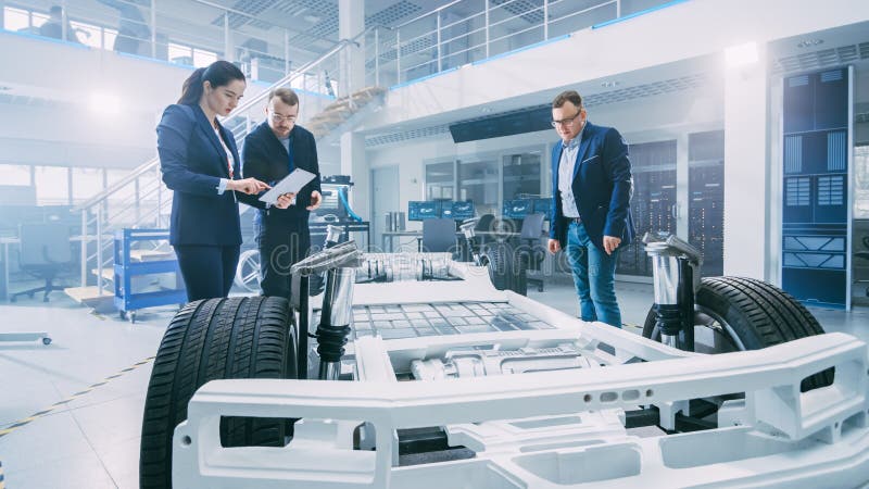 Automotive Design Engineers Talking while Working on Electric Car ...