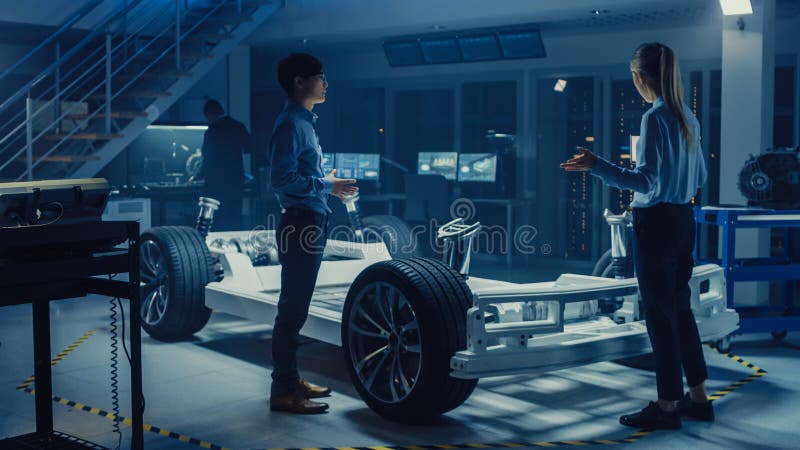Automotive Design Engineers Talking while Working on Electric Car ...