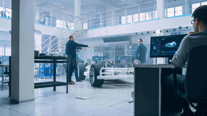 Automotive Design Engineers Talking while Working on Electric Car ...