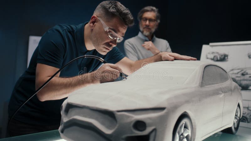 Automotive Engineer Works on Sculpture of a Car while Discussing with ...