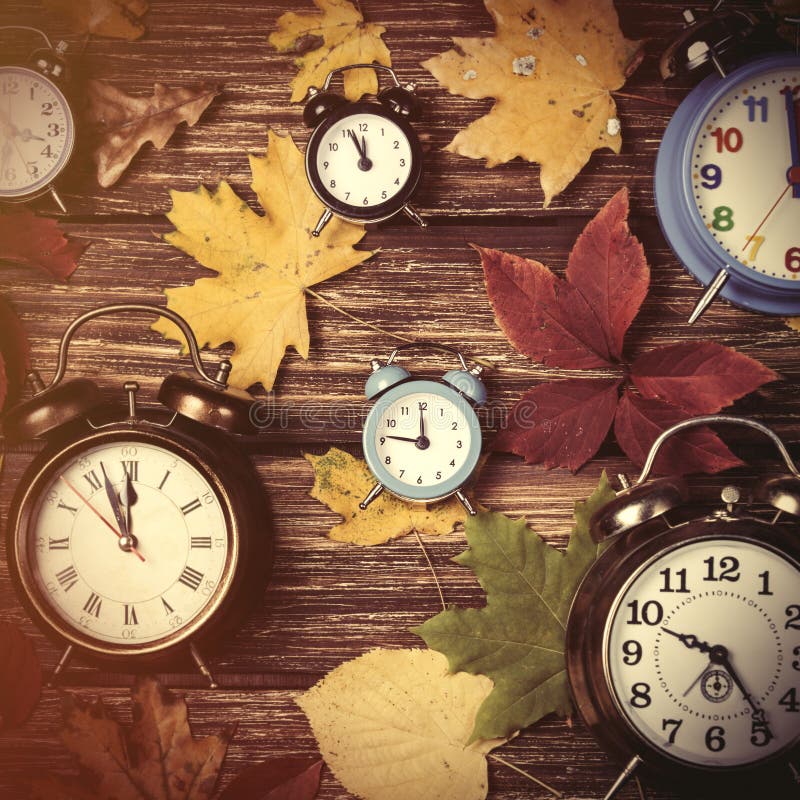 Autumn Leafs and Alarm Clock on Table. Stock Photo - Image of morning ...
