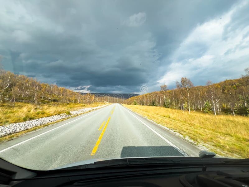 Autumnal Forest and Dramatic Dark Clouds Over a Straight Asphalt Road ...