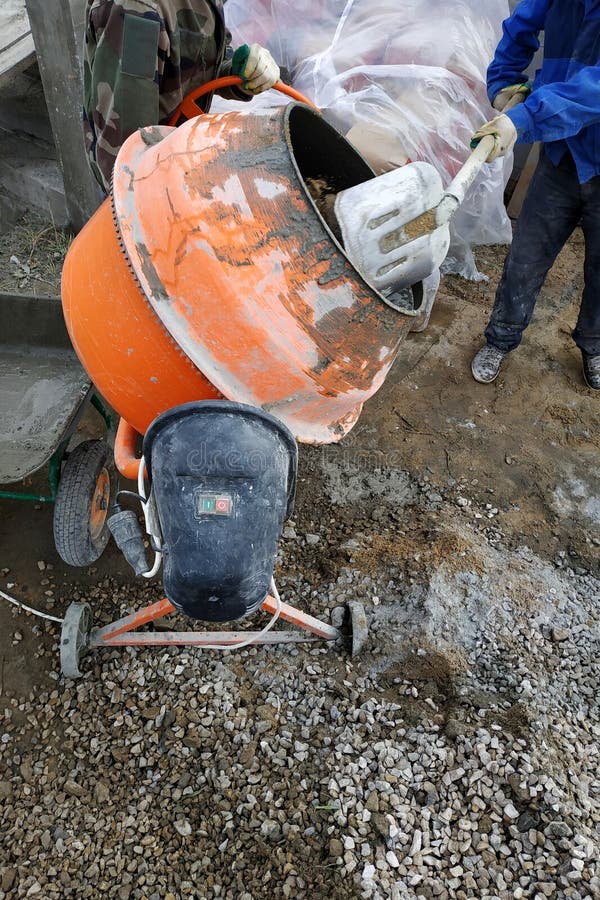 Auxiliary Worker Develops a Cement Mortar in a Concrete Mixer at the ...
