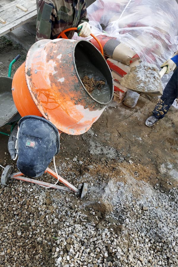 Auxiliary Worker Develops a Cement Mortar in a Concrete Mixer at the ...