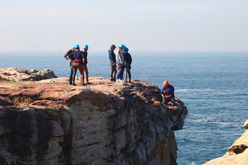 Aventura De Abseil De Los Escaladores Con Los Cascos Rappelling Abajo