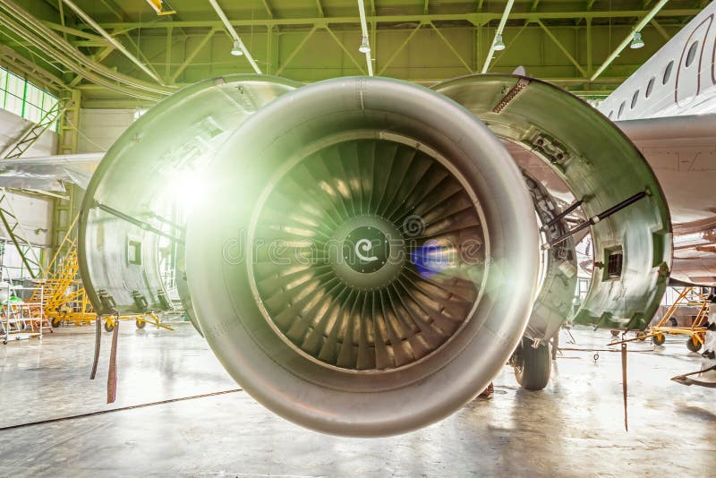 Aviation Maintenance Inside Hangar with a Flash Light Inspects Airplane ...