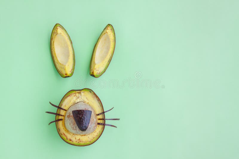 Avocado Cut in Half and Slice on Green Background, Rabbit Shaped of ...