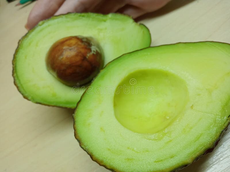 Avocado cut with pit stock photo. Image of green, avocado - 261883654
