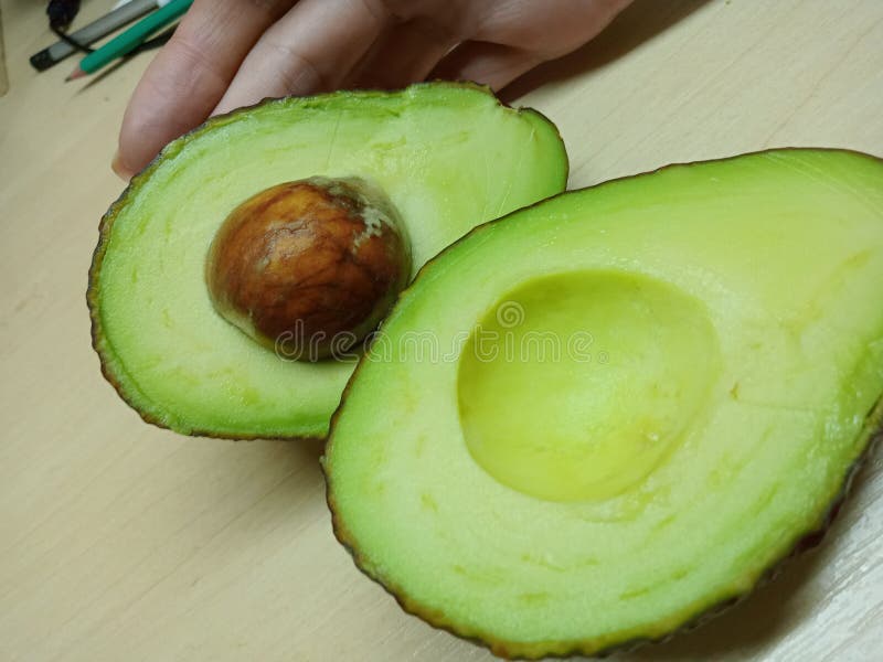 Avocado cut with pit stock image. Image of brown, green - 261883739