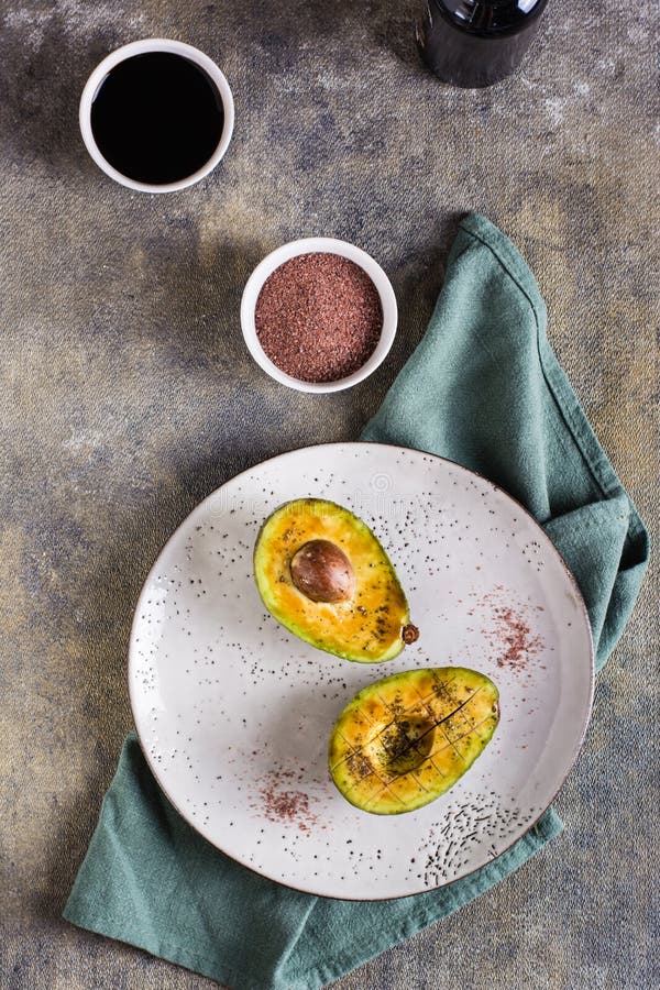 Avocado Halves with Black Himalayan Salt on a Plate on the Table. Top ...