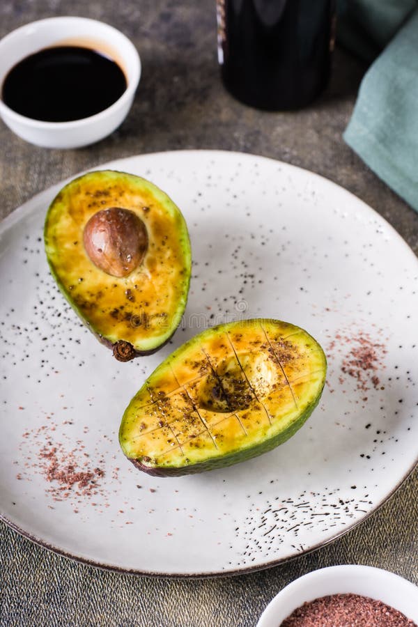 Avocado Halves with Black Himalayan Salt on a Plate on the Table ...