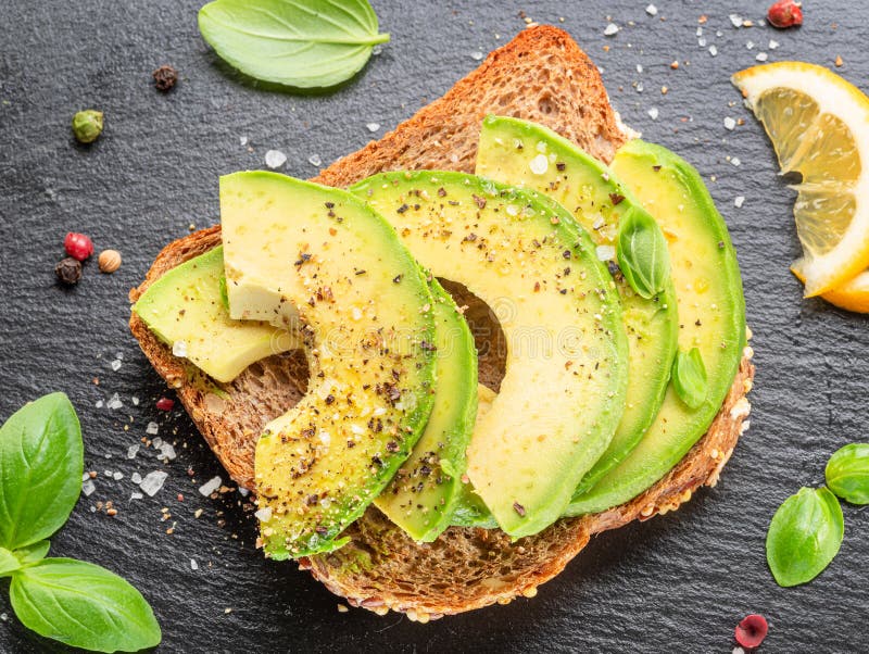 Avocado Toast - Bread with Avocado Slices on Natural Slate Serving ...