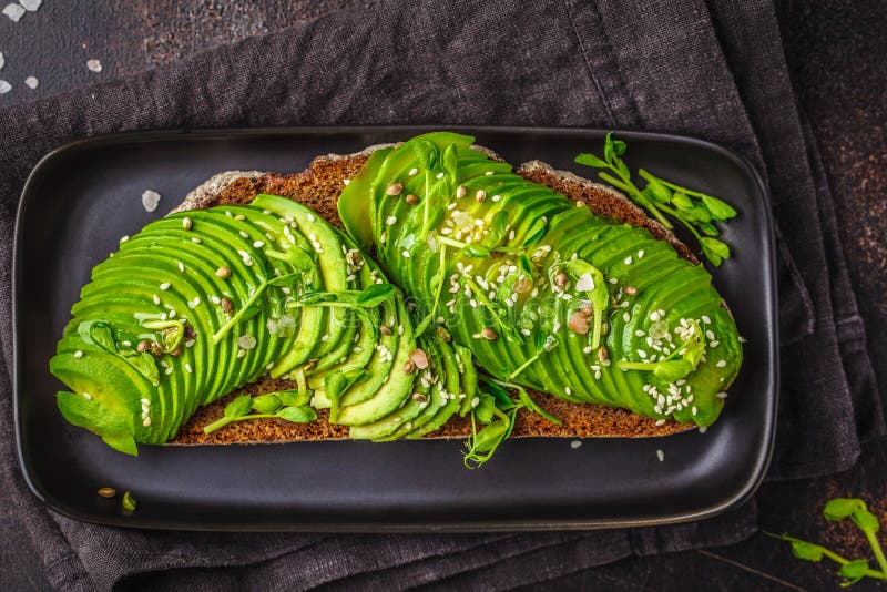 Avocado Toast with Rye Bread and Seeds on Black Plate, Dark Background ...