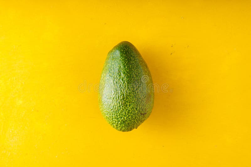 Avocado on a yellow table stock photo. Image of herb - 82821586
