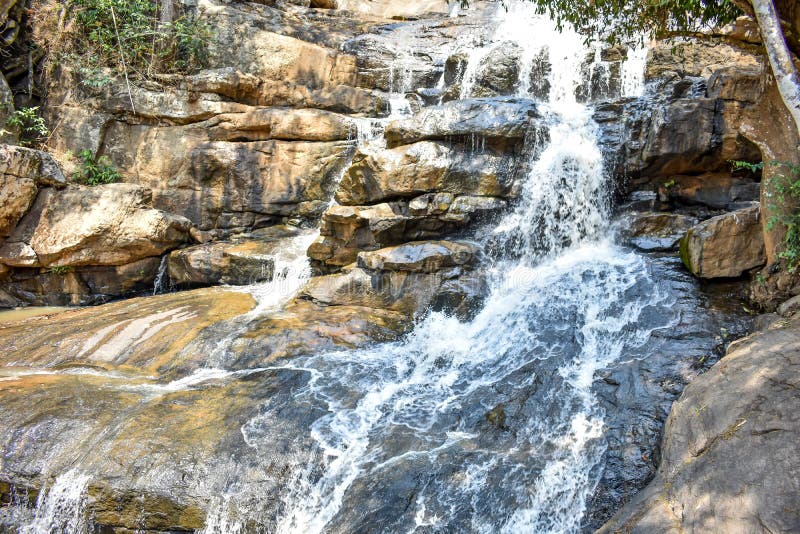 Awesome View of Waterfall Passing through a Mountain Big Rock Near by ... Awesome View of Waterfall Passing through a Mountain Big Rock Near by ...