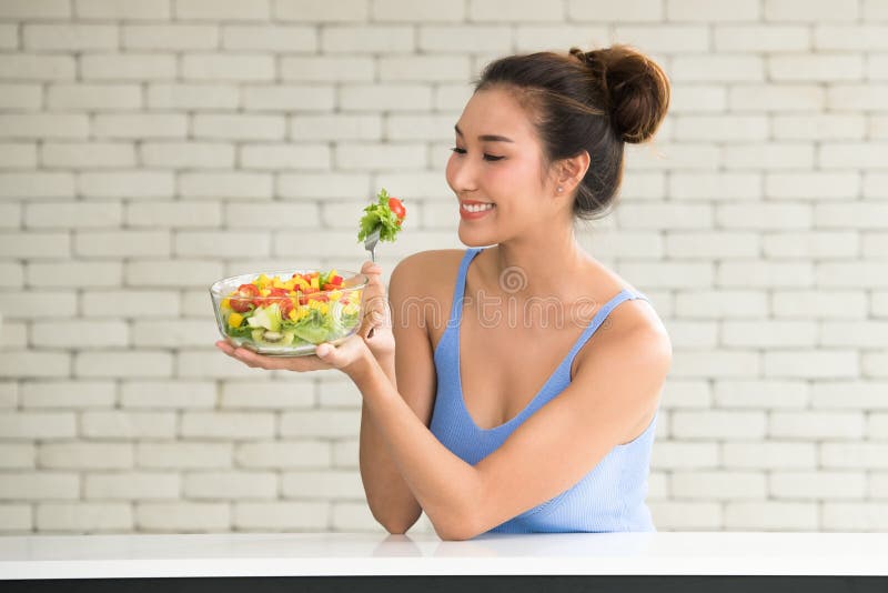 Aziatische Vrouw in Blije Houdingen Met De Salade Van De Handholding ... Aziatische Vrouw in Blije Houdingen Met De Salade Van De Handholding ...