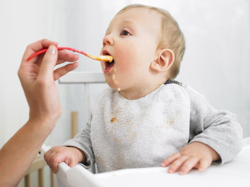 Messy Baby Being Fed stock image. Image of feeding, camera - 12021291