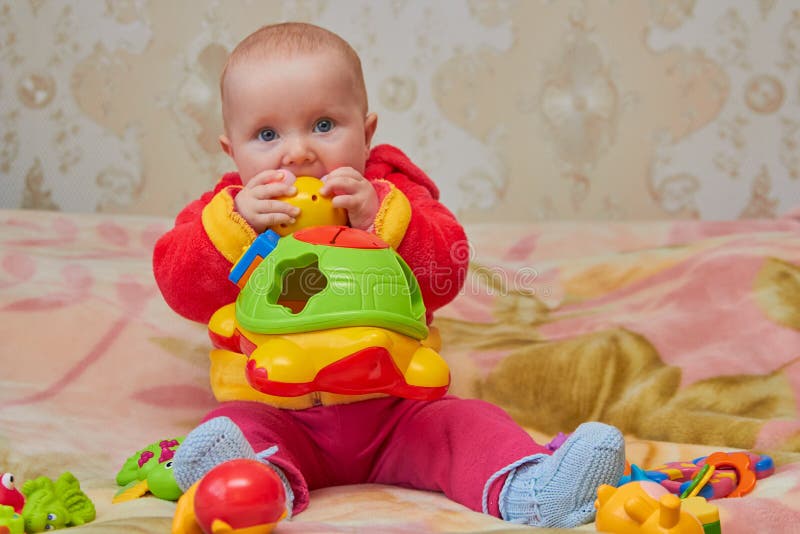 Baby Bites a Toy,the Baby Bites the First Teeth of a Plastic Toy on the ...